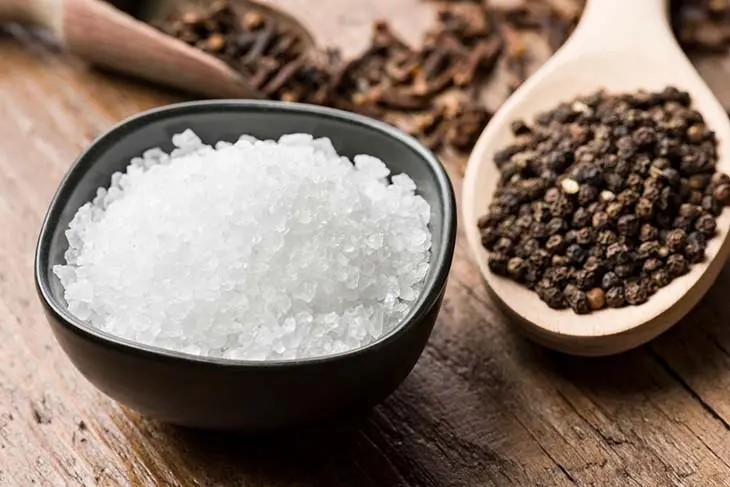 Why is it important to sprinkle cloves and salt in front of the house door?